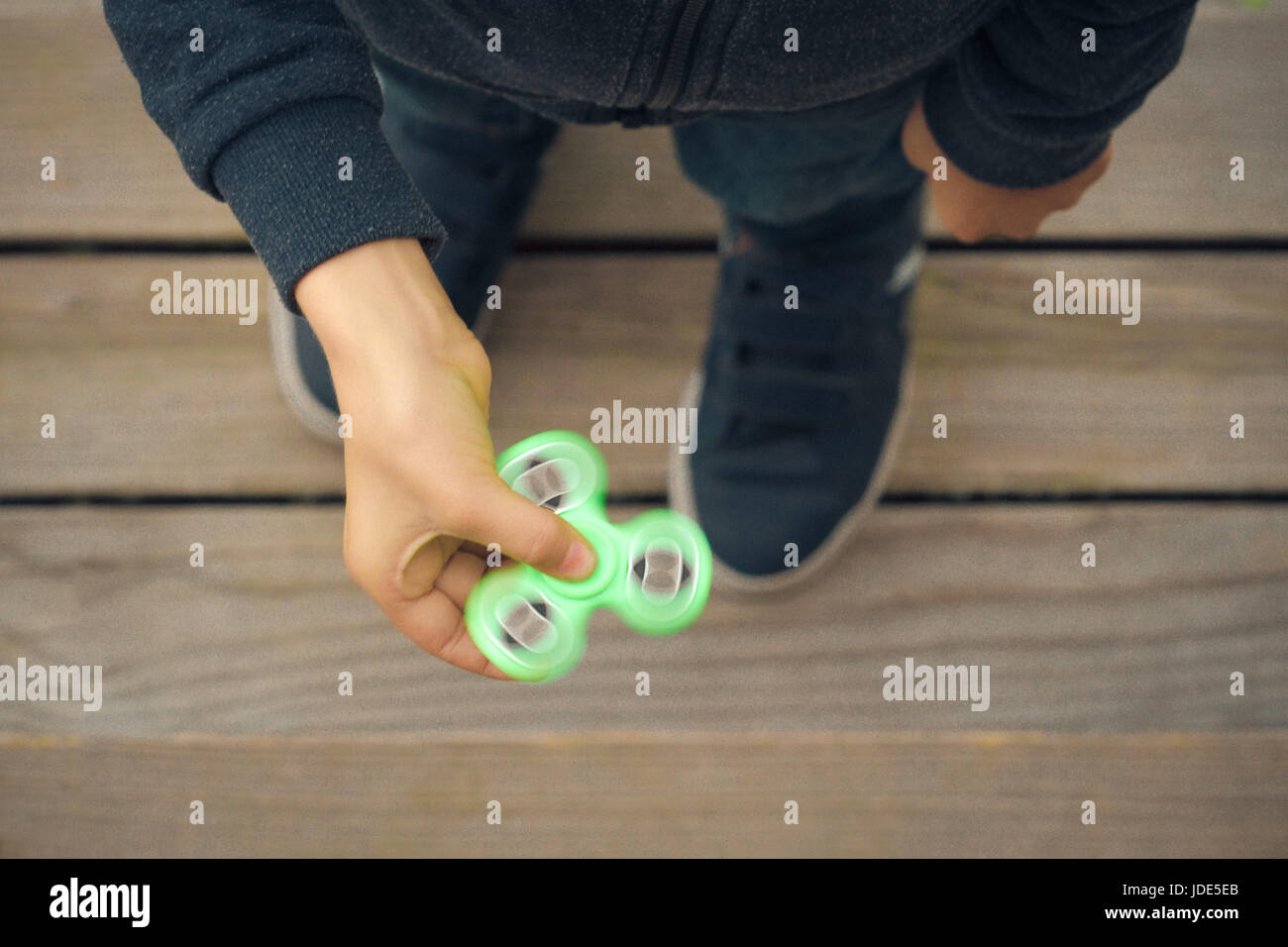 Boy holding popular fidget spinner toy. Top view Stock Photo - Alamy
