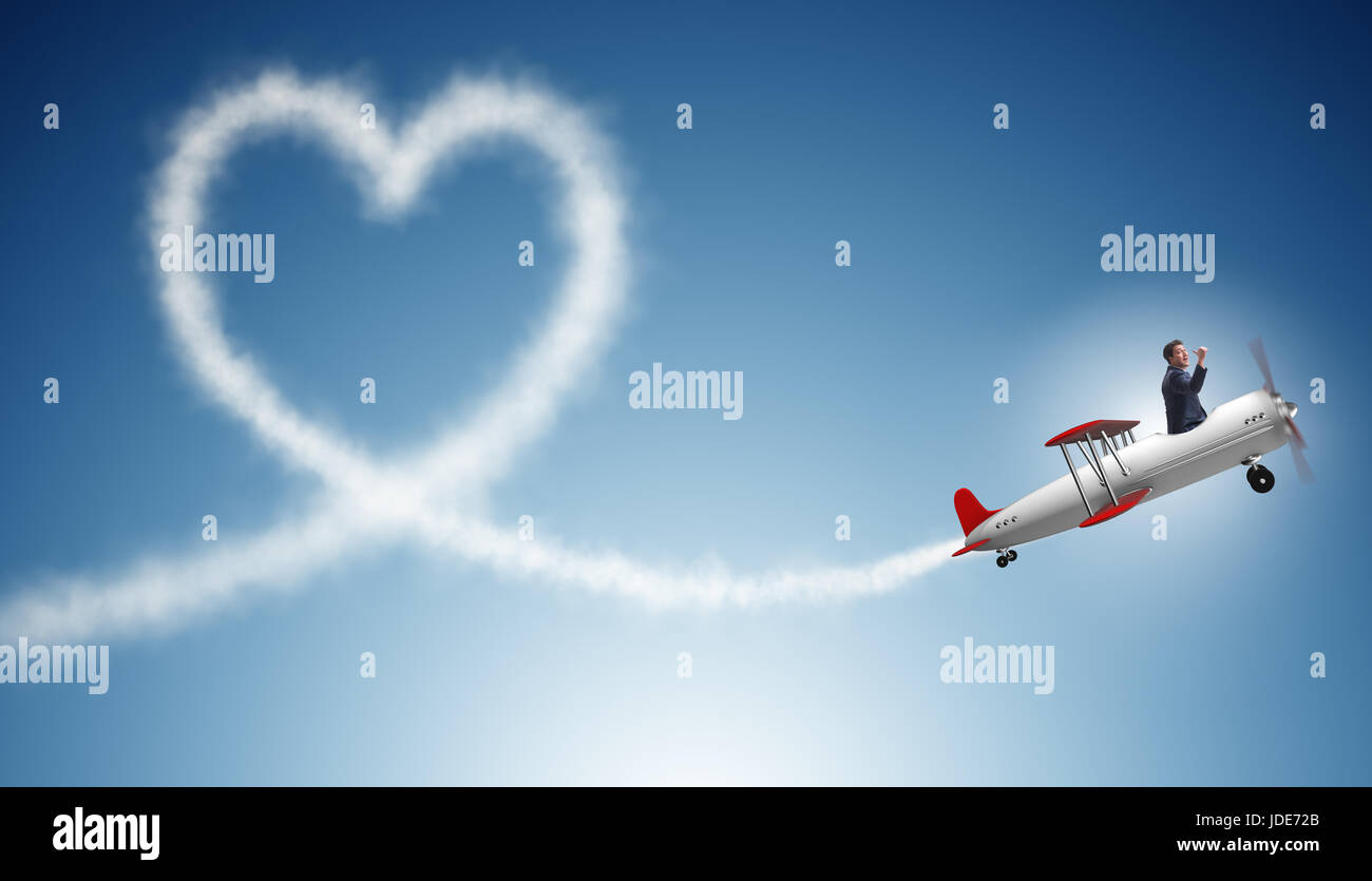 Man flying airplane and making heart shape Stock Photo - Alamy