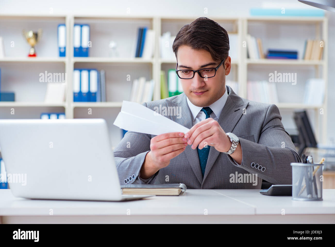 Businessman with paper airplane in office Stock Photo - Alamy