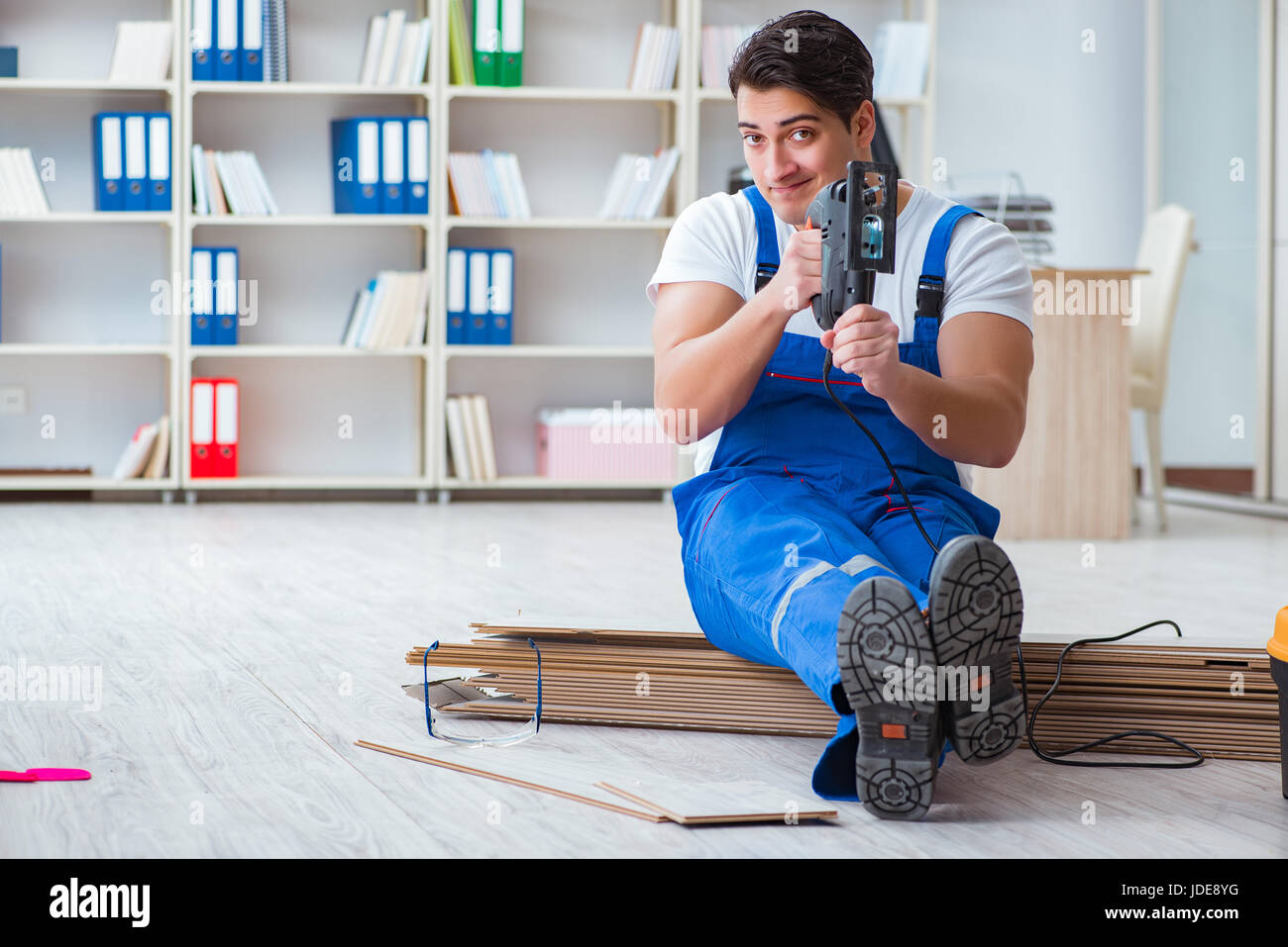 Young worker working on floor laminate tiles Stock Photo - Alamy