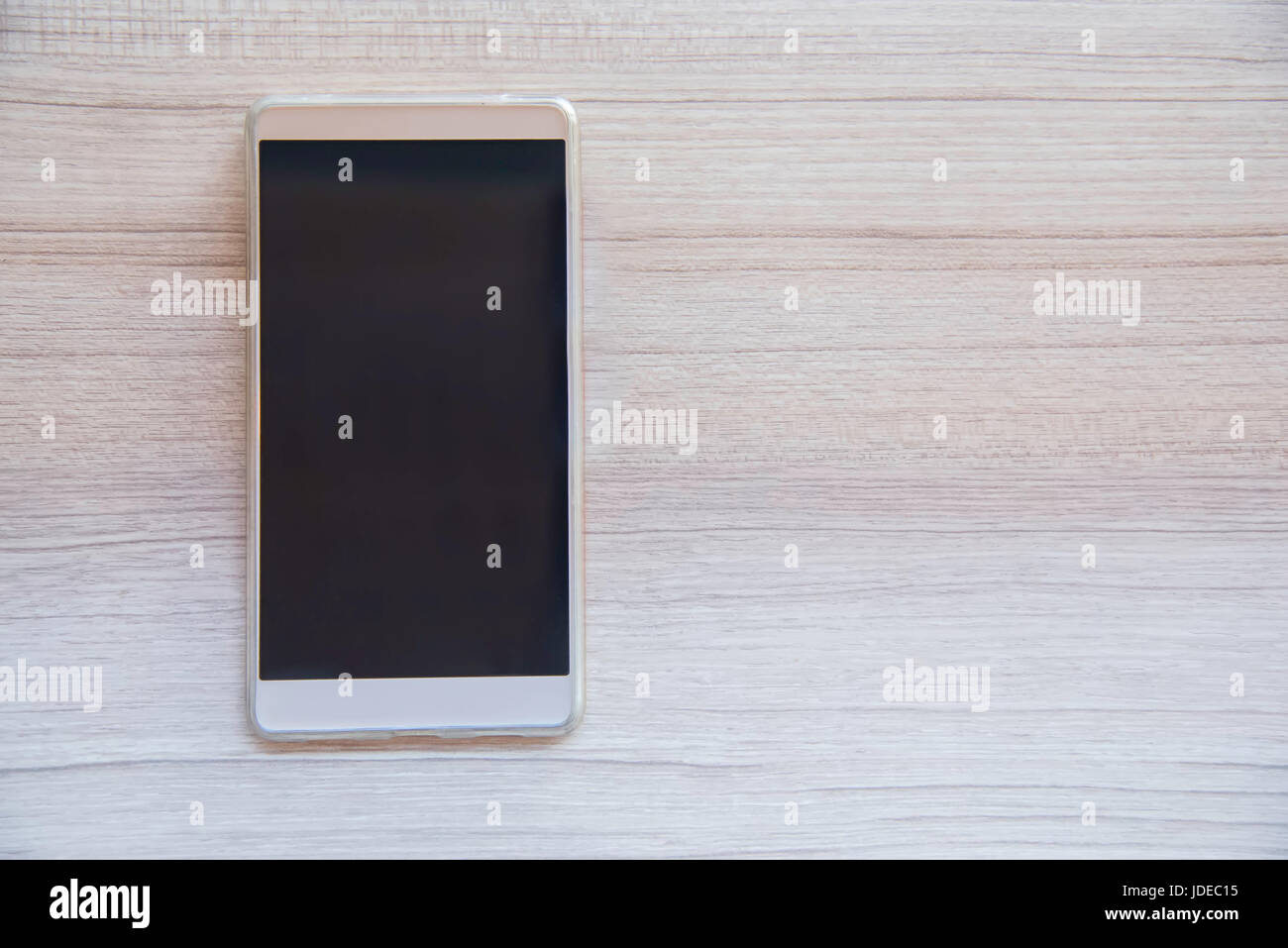 smarth phone on wooden table with blank screen Stock Photo - Alamy