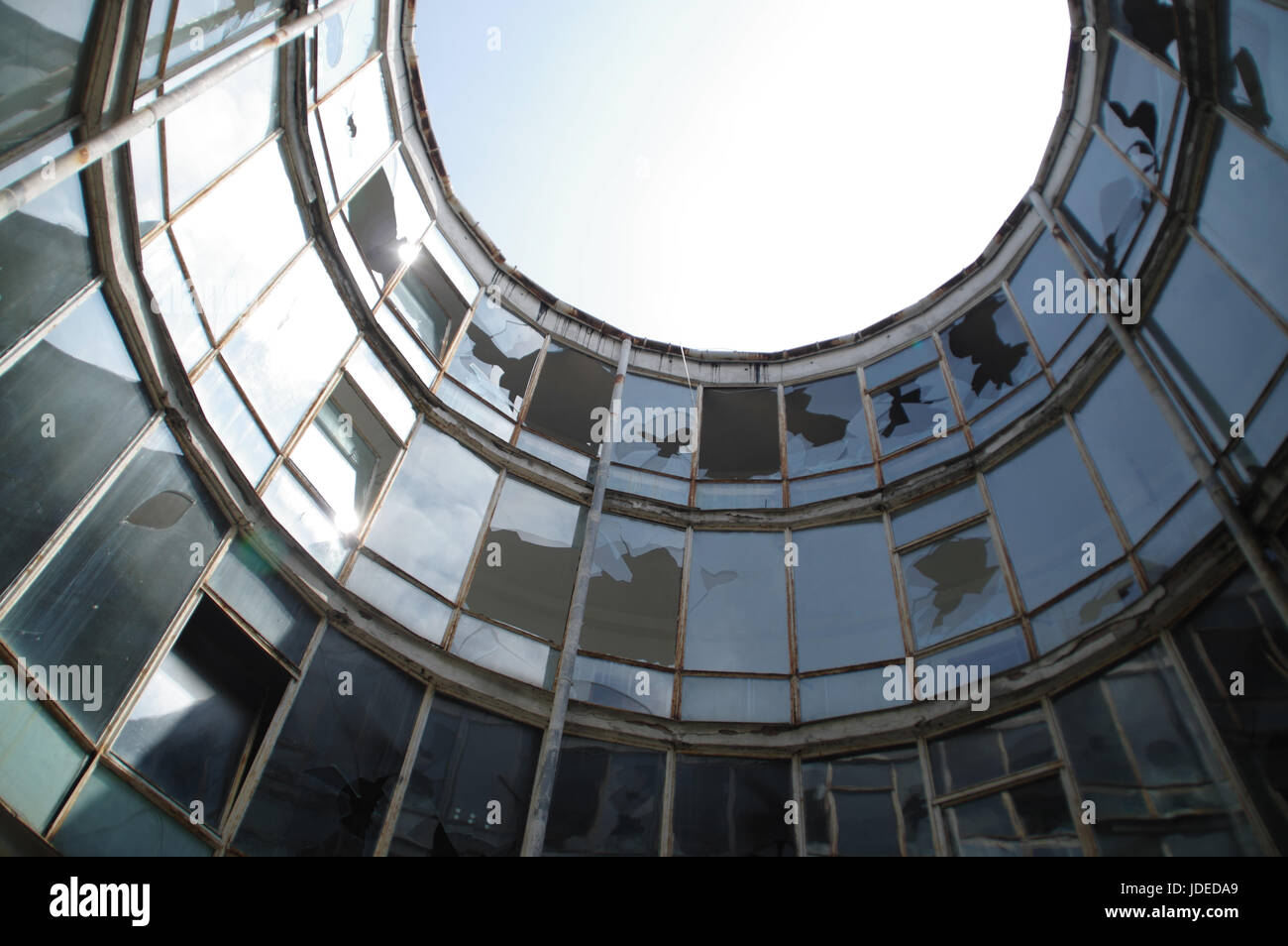 Forgotten round building with shattered glass. Broken windows pane ...