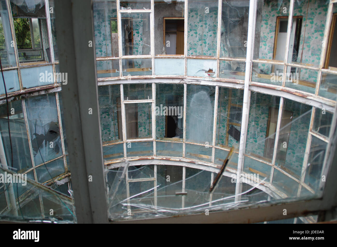 Forgotten round building with shattered glass. Broken windows pane ...