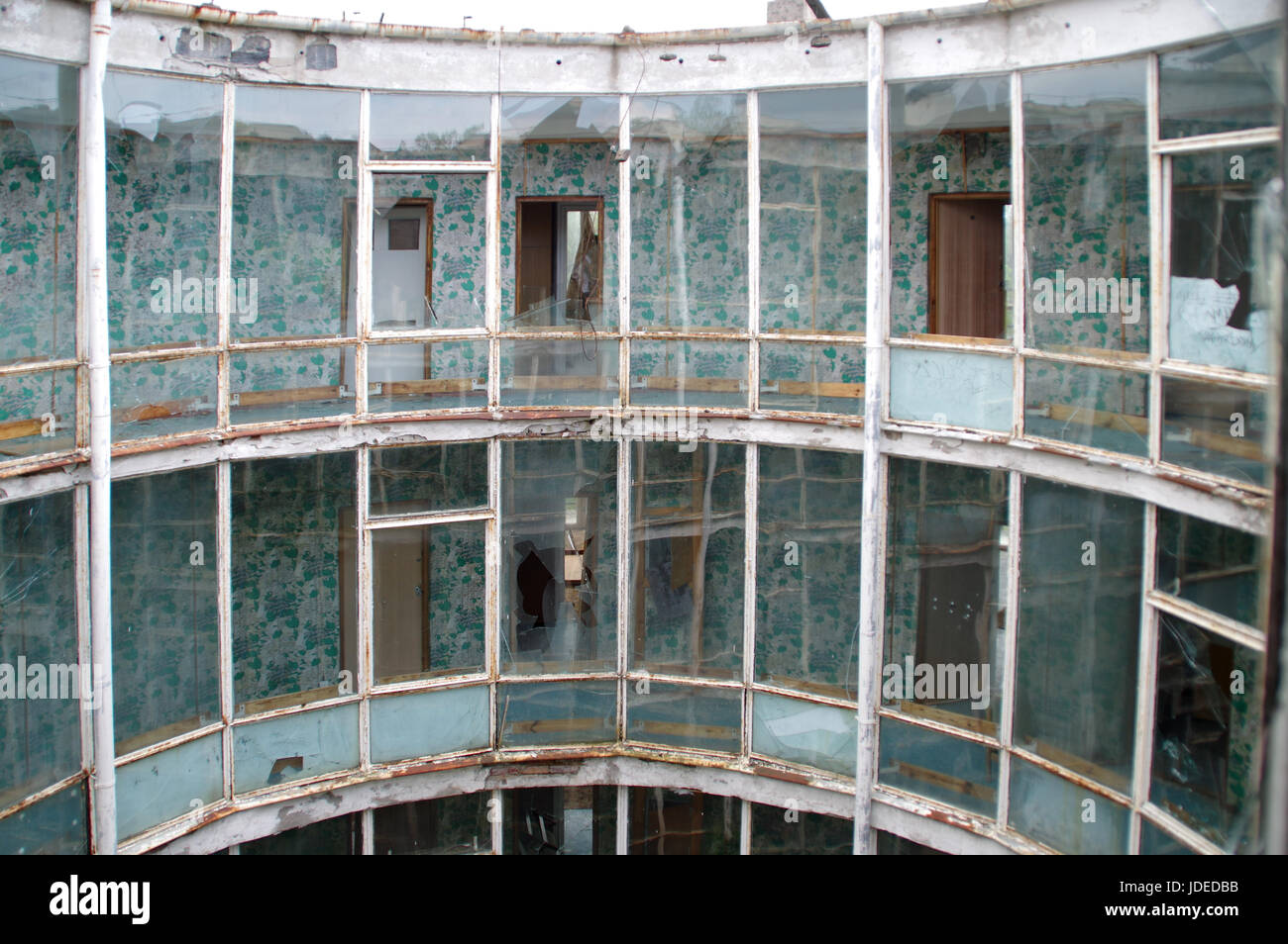 Forgotten round building with shattered glass. Broken windows pane ...