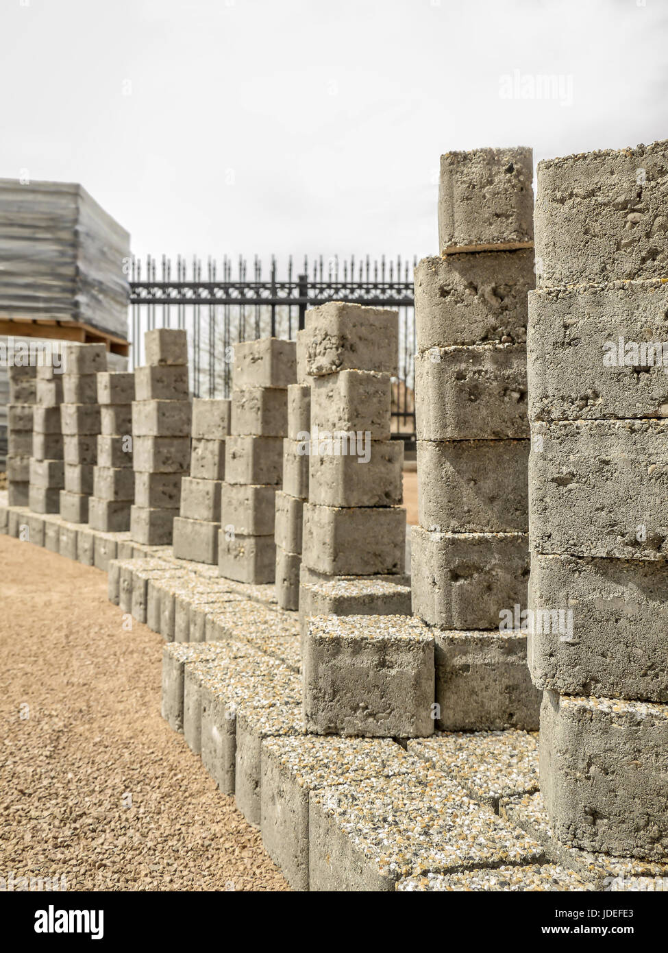 Groups of concrete pavement blocks with mineral topping stacked along ...