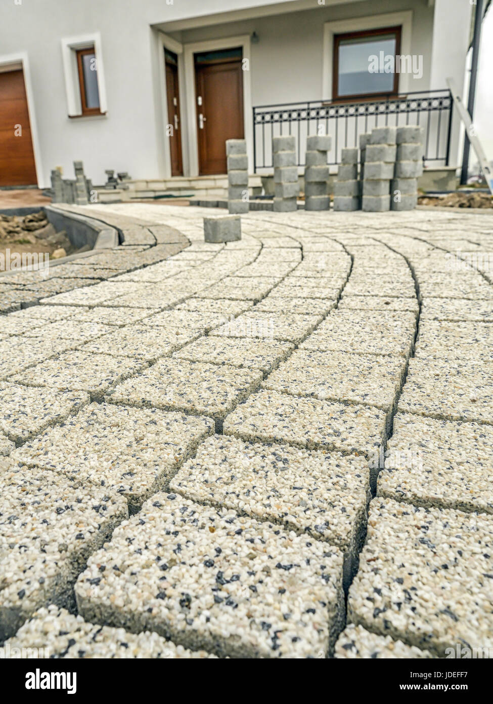 Pavement path laid from light creme concrete pavement blocks with ...