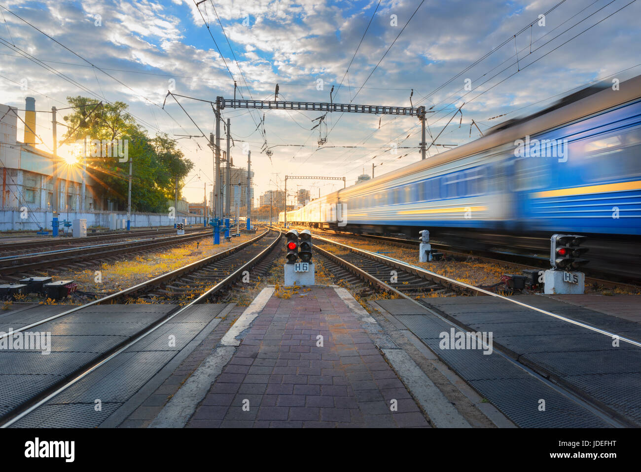 High speed passenger train in motion on railroad track at sunset ...
