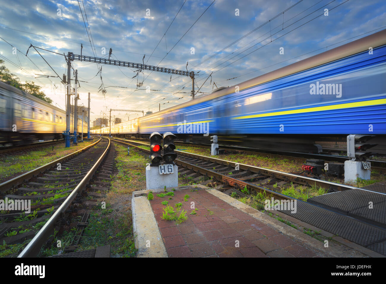 High speed passenger train in motion on railroad track at sunset ...
