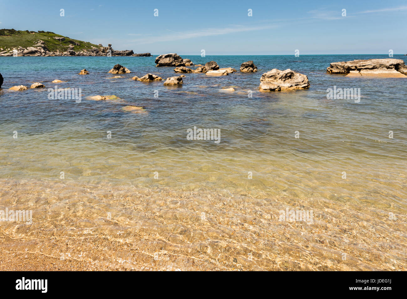 Beautiful beach and the rocks in the shallow water Stock Photo - Alamy