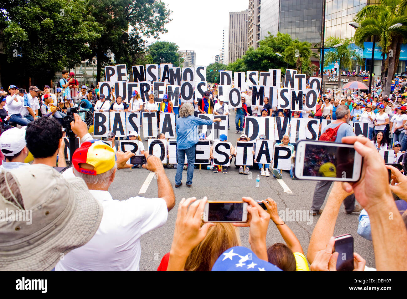 People using cardboard signs protest peacefully on a street in Caracas ...