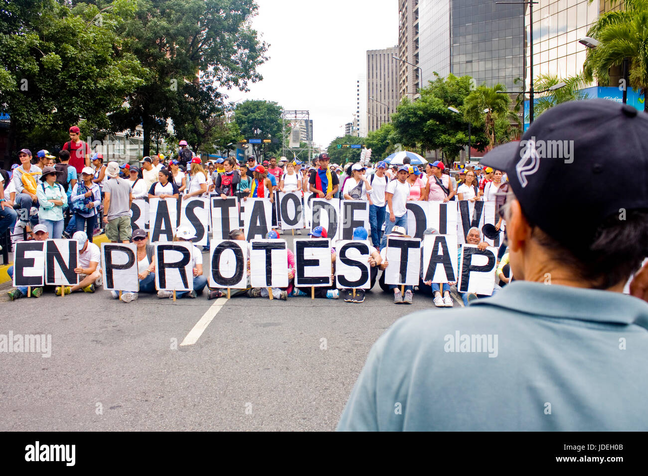 People using cardboard signs protest peacefully on a street in Caracas ...