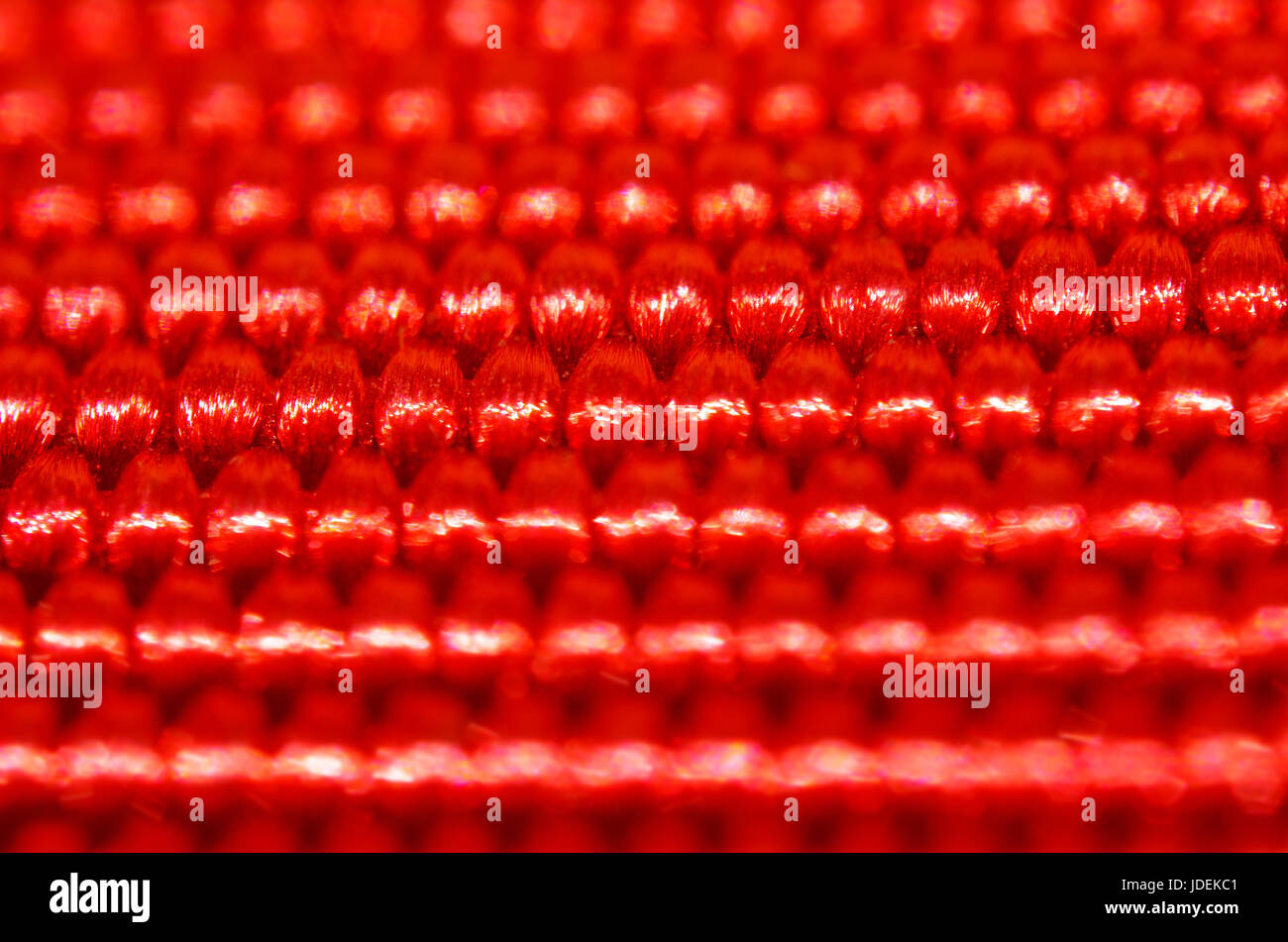 Red nylon belt close-up. Shallow depth of field. The interweaving of ...