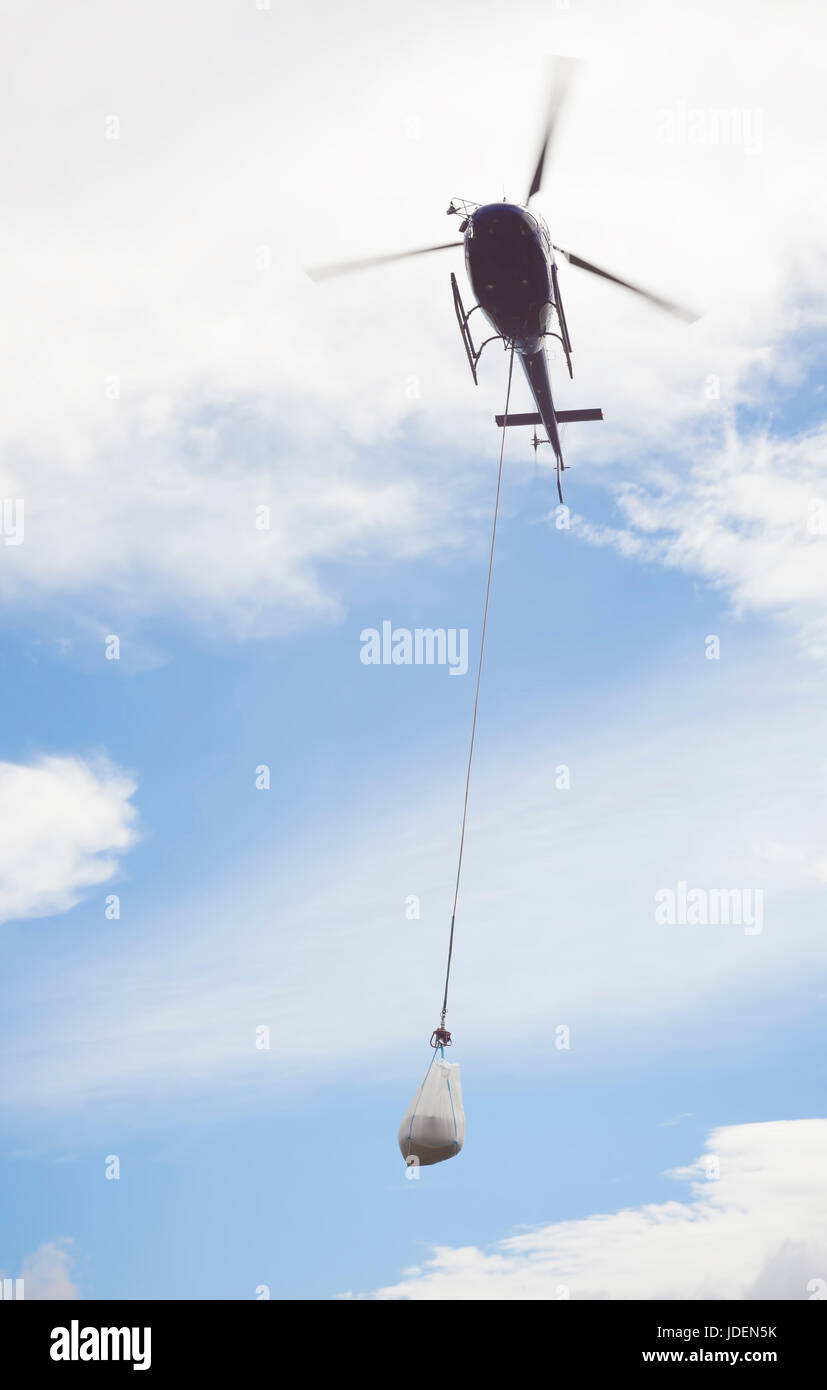 helicopter carry sand for construction industry Stock Photo - Alamy