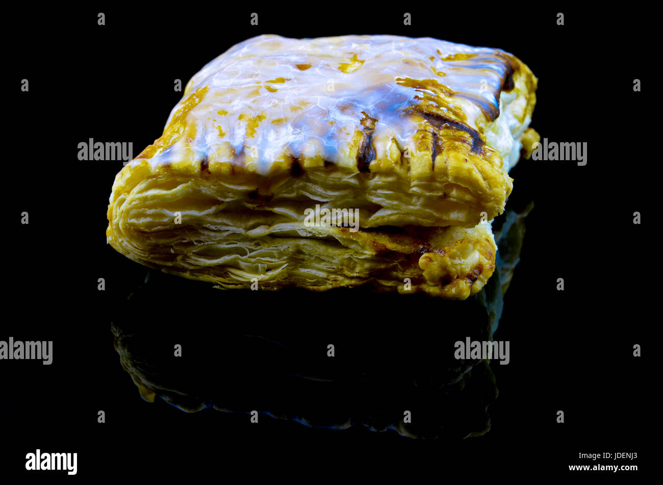 Crisp puff pastry filled with jam sugar-coated on black background ...