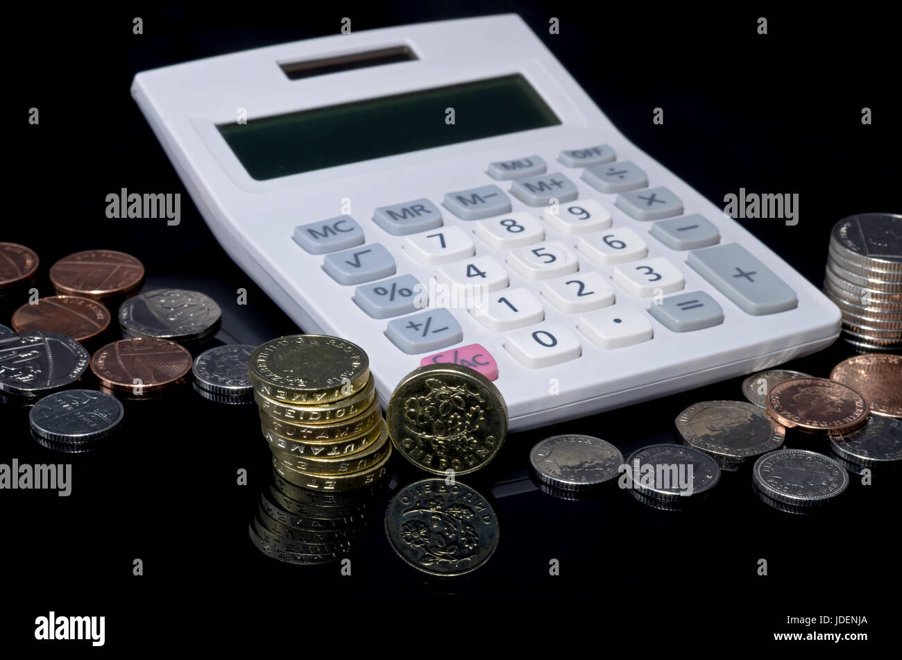 Calculator and coins british pounds on black background Stock Photo - Alamy