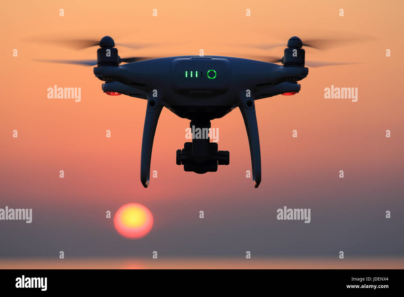 Remote controlled drone equipped with video camera flying in air and ...
