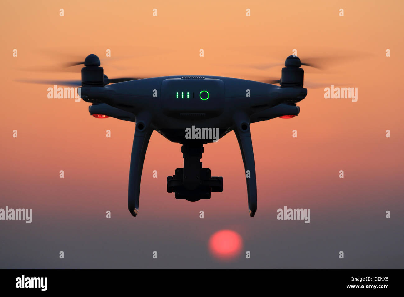 Remote controlled drone equipped with video camera flying in air and ...