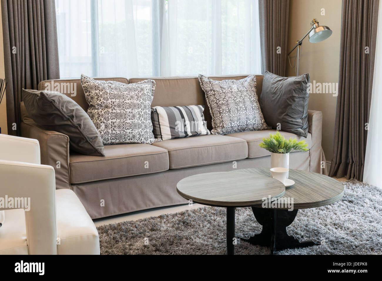 Sturdy brown tweed sofa with grey patterned pillows Stock Photo - Alamy