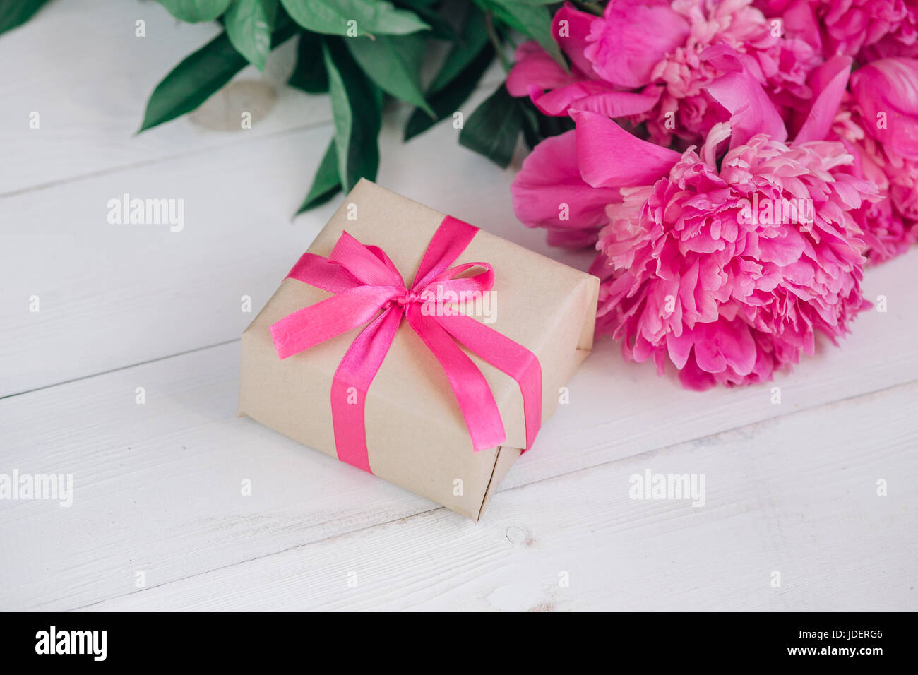 Beautiful fresh pink peony flower with gift box on wooden background ...