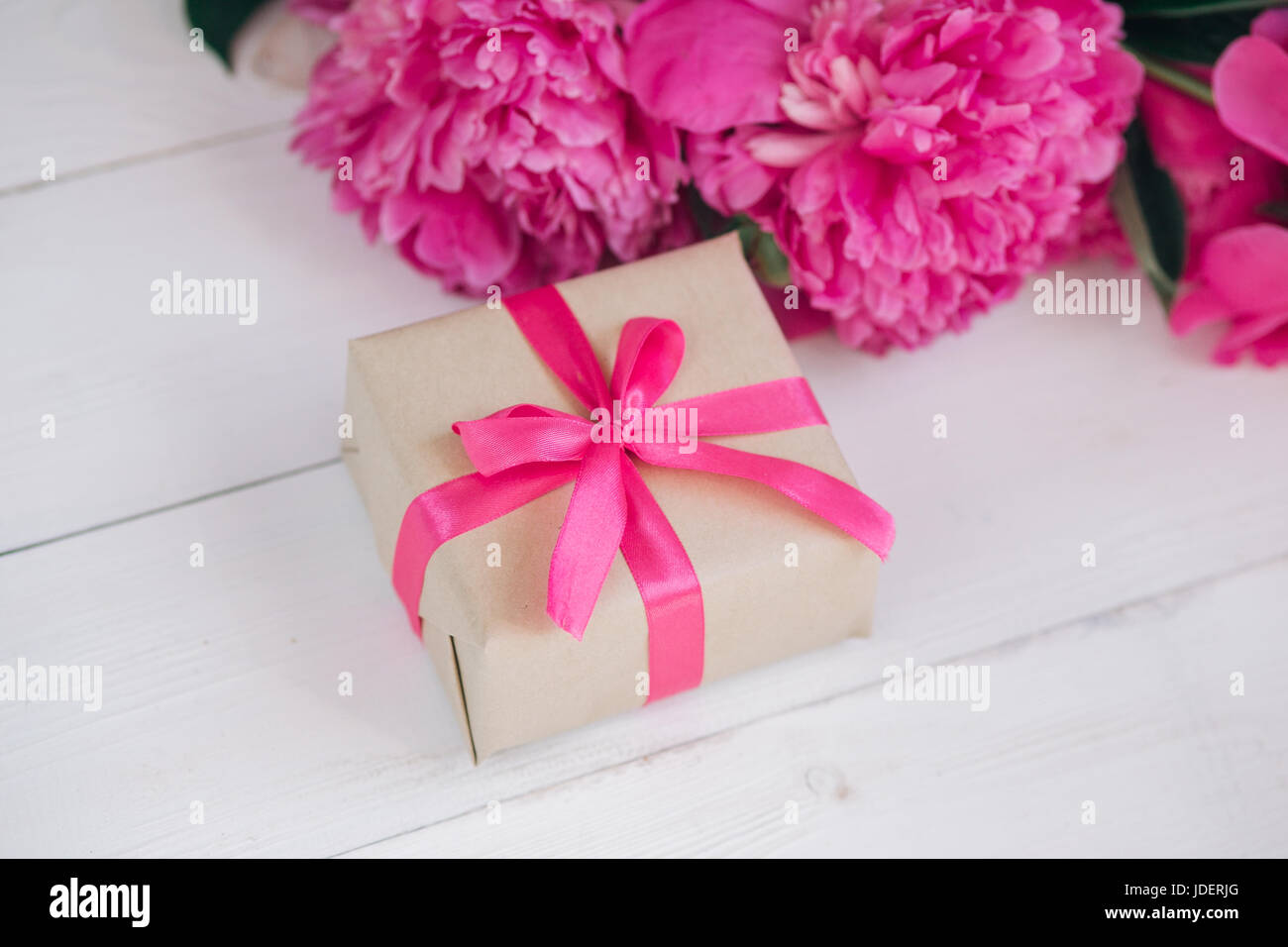 Beautiful fresh pink peony flower with gift box on wooden background ...
