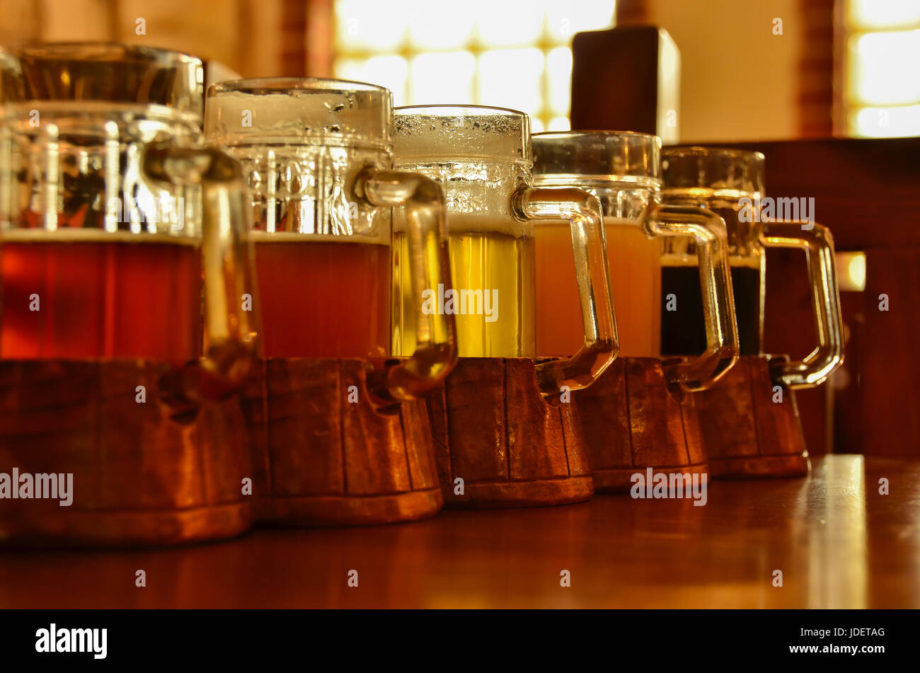 Five glasses different taste of beer stand in a row on the bar table ...