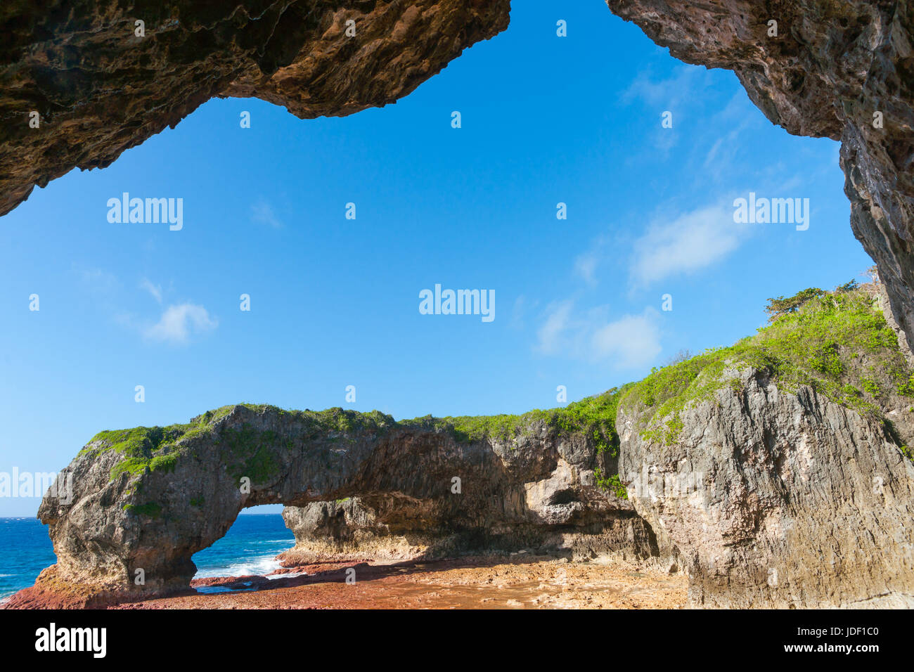 Scenic natural arch on coast of island Talava Arch framed by coral ...