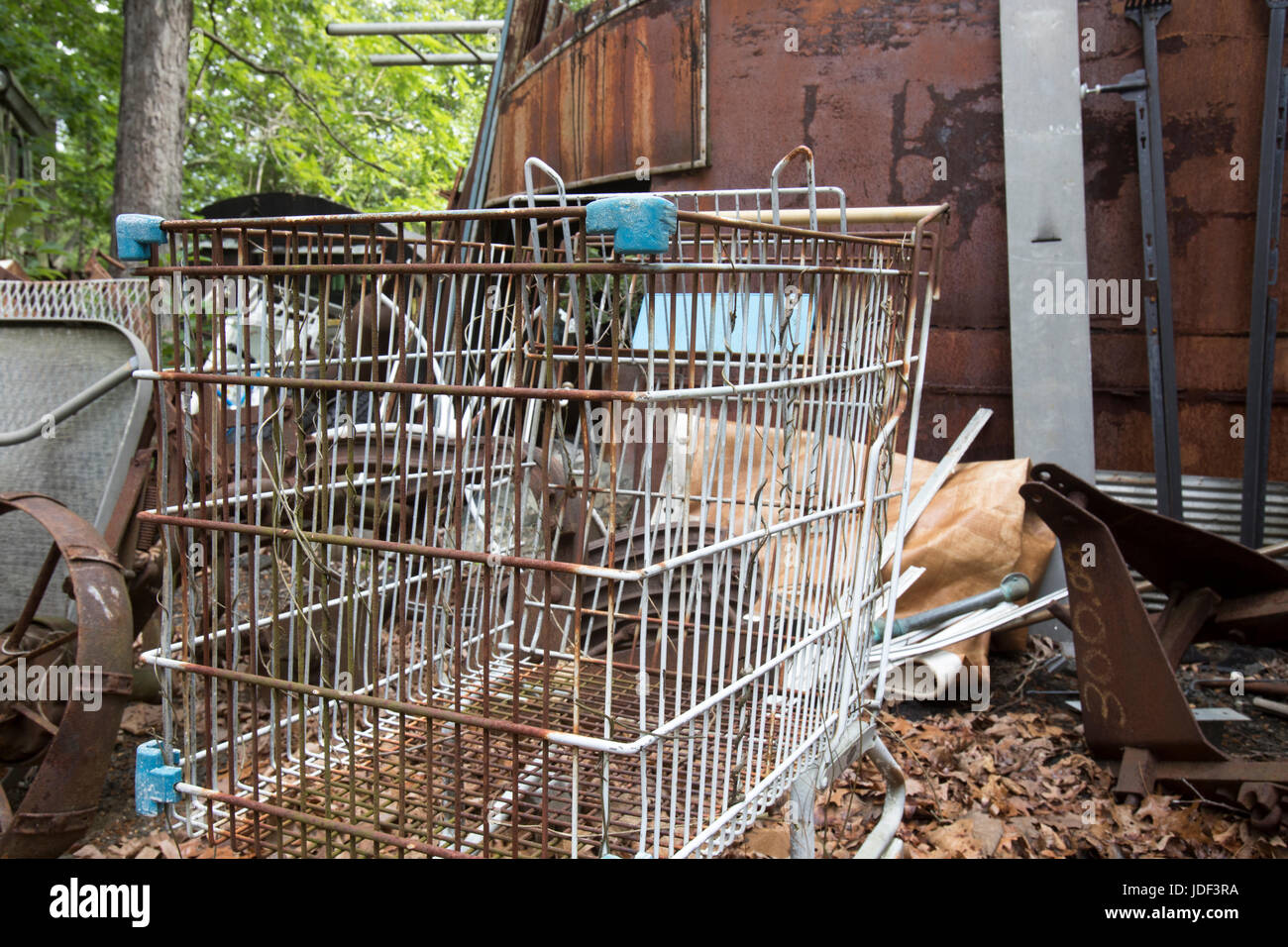 Rusting shopping cart and scrap metal in junkyard Stock Photo - Alamy