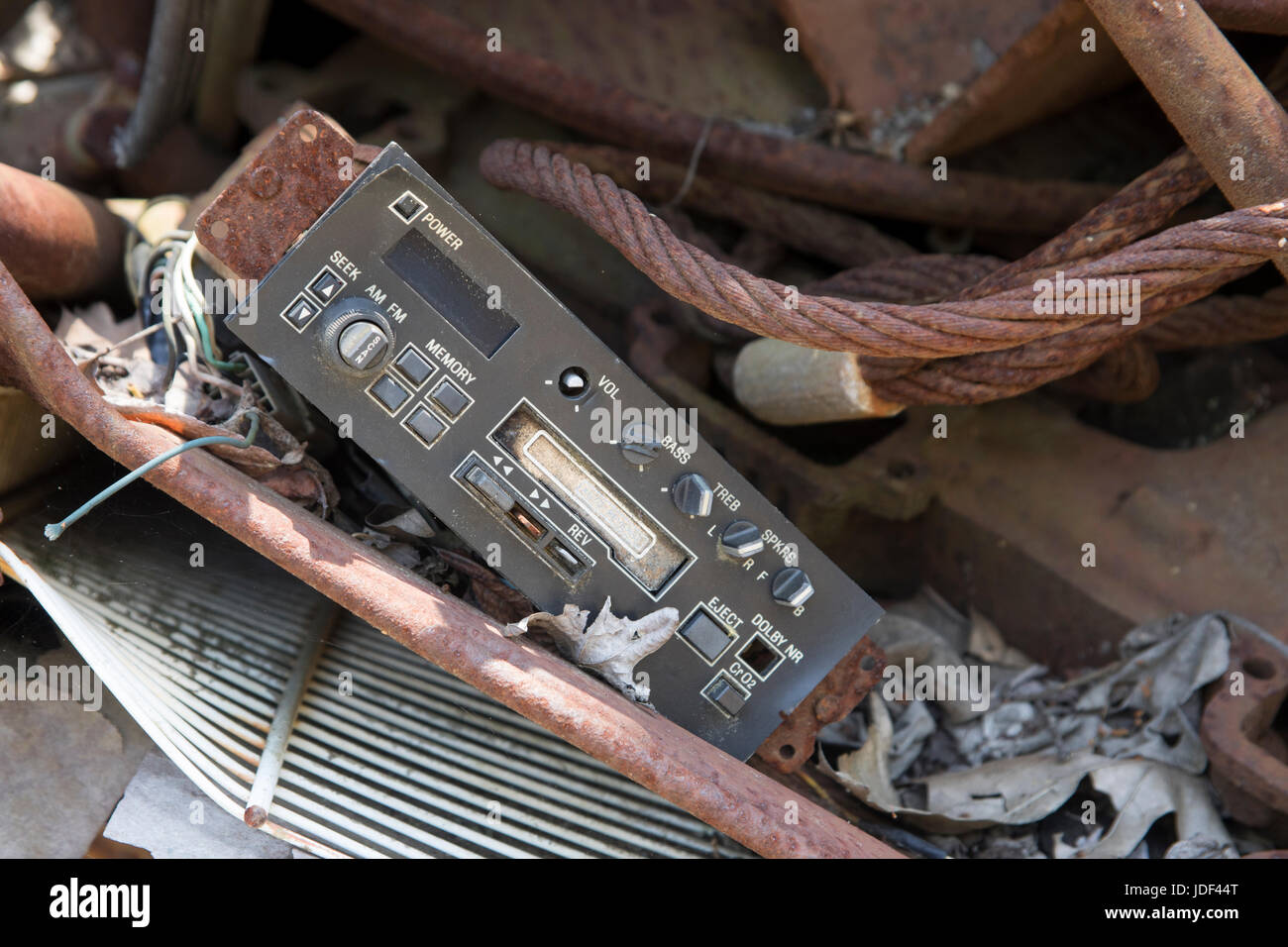 Automotive stereo cassette player and radio on salvage pile in junkyard ...
