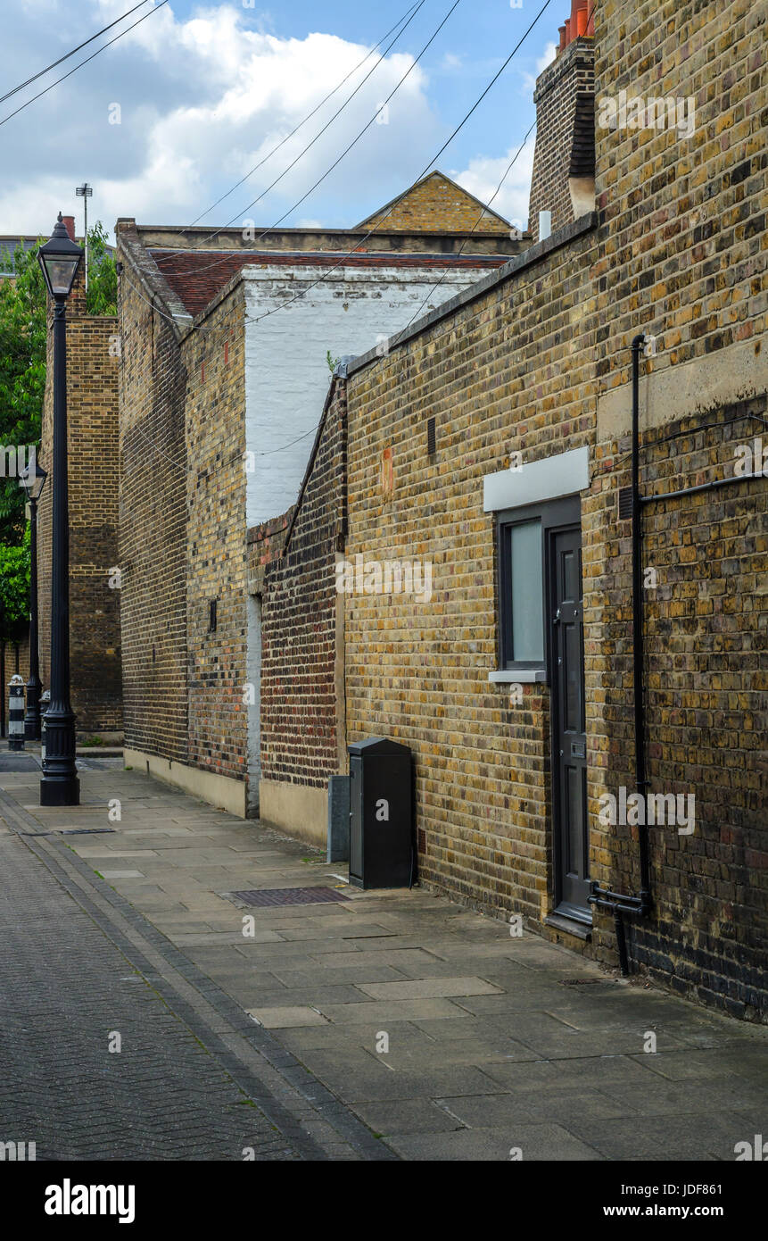 Typical old English buildings, low brick buildings across a narrow ...
