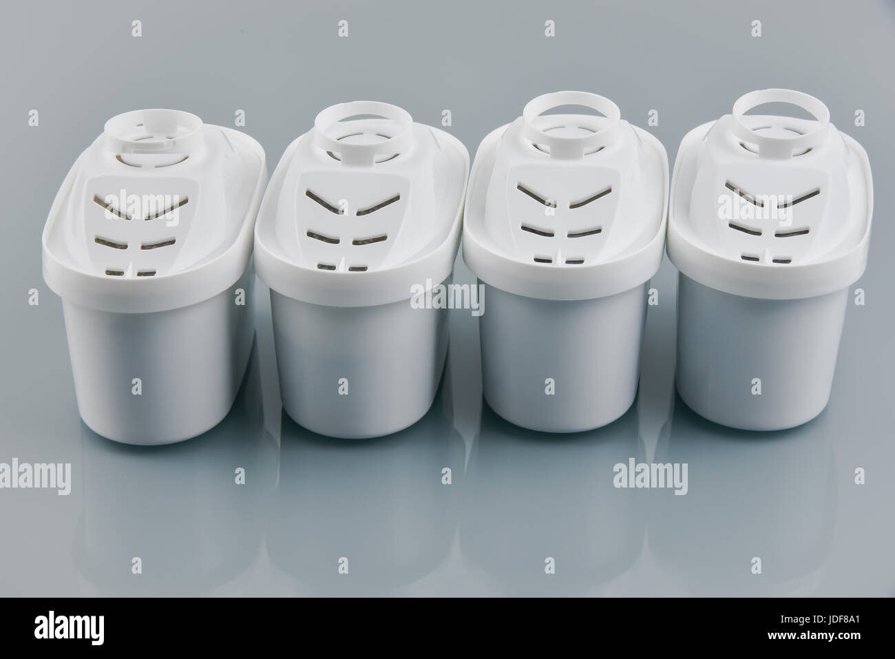 Set of four water filters in row on grey background Stock Photo - Alamy