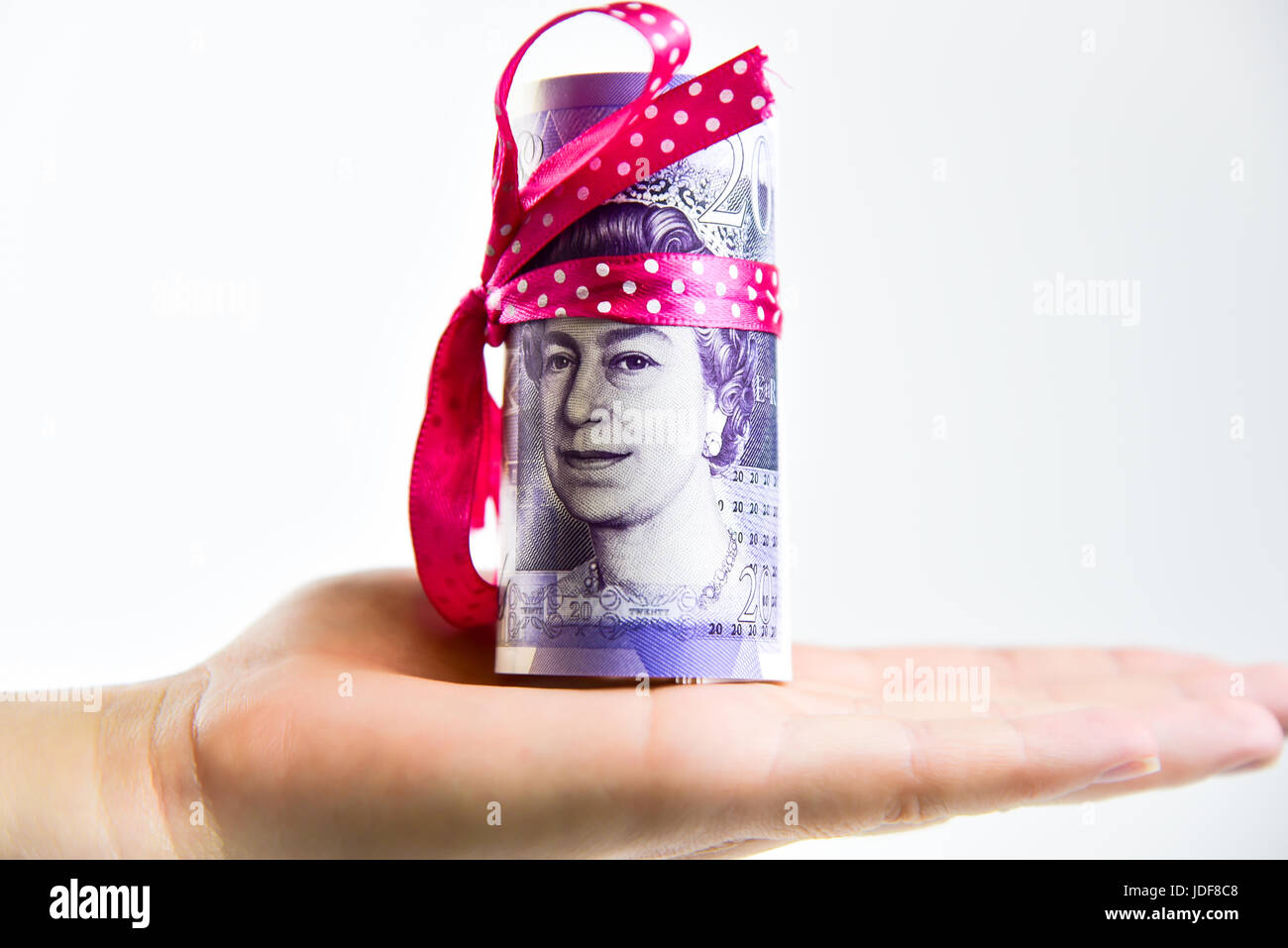 Hand holding bundle of banknotes tied in a bow isolated on white Stock ...