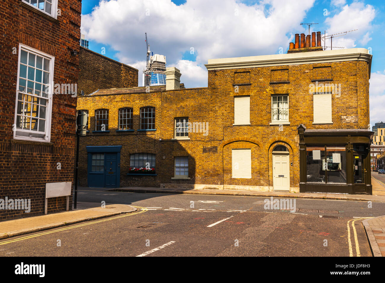Typical old English buildings, low brick buildings across a narrow ...
