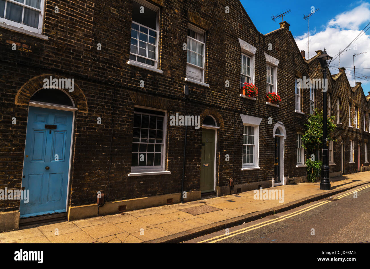 Typical old English buildings, low brick buildings across a narrow ...