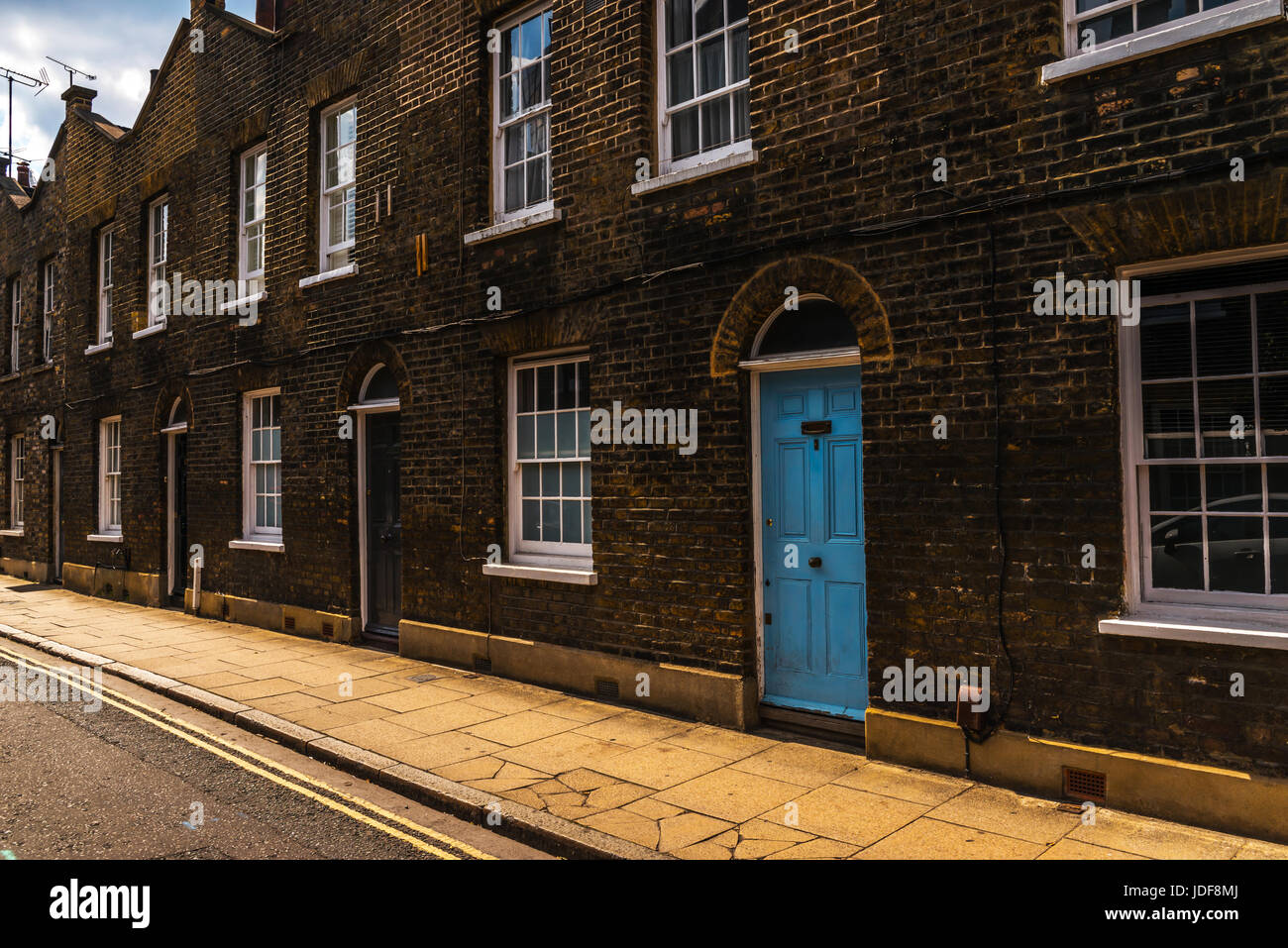 Typical old English buildings, low brick buildings across a narrow ...