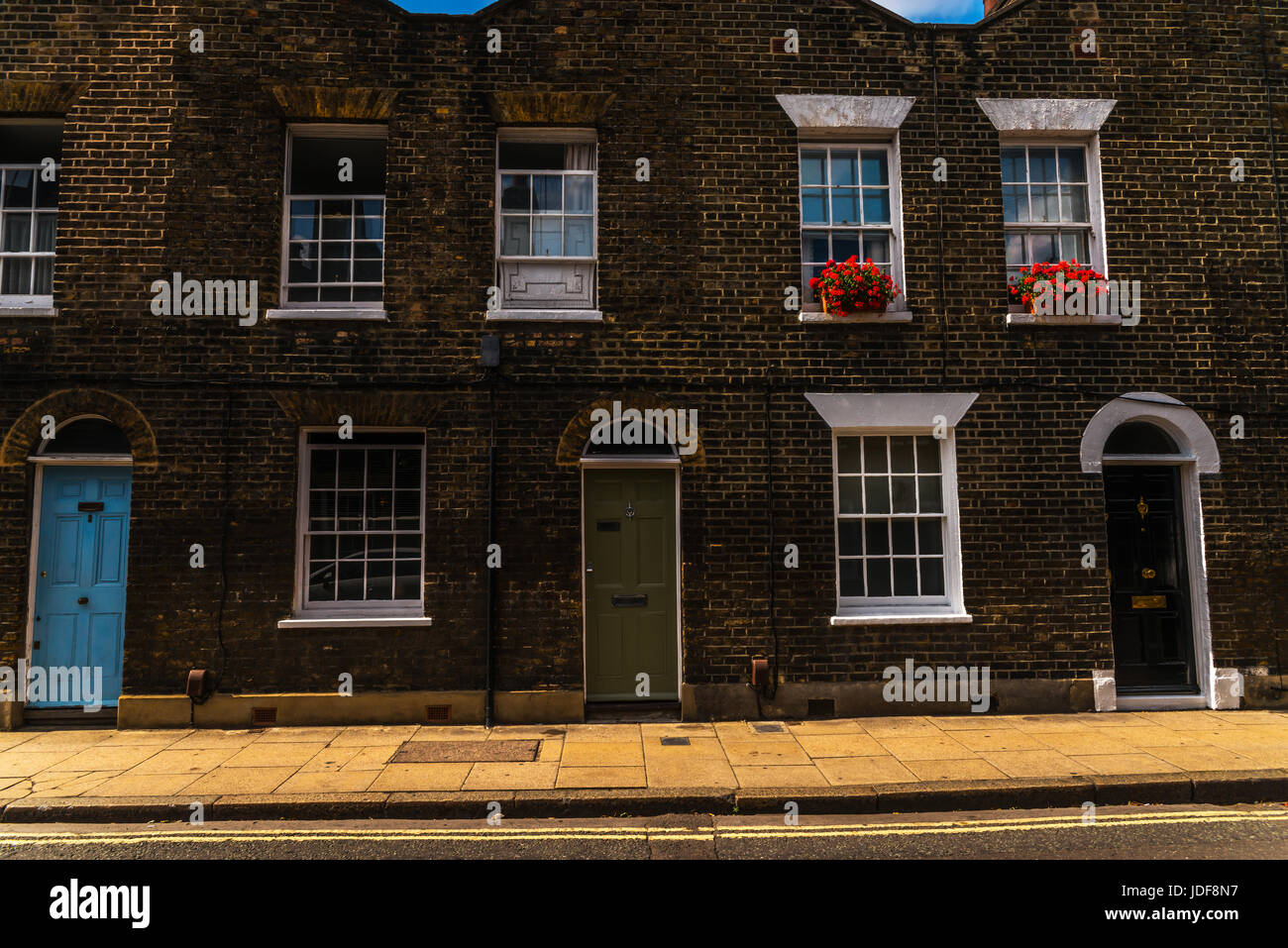 Typical old English buildings, low brick buildings across a narrow ...