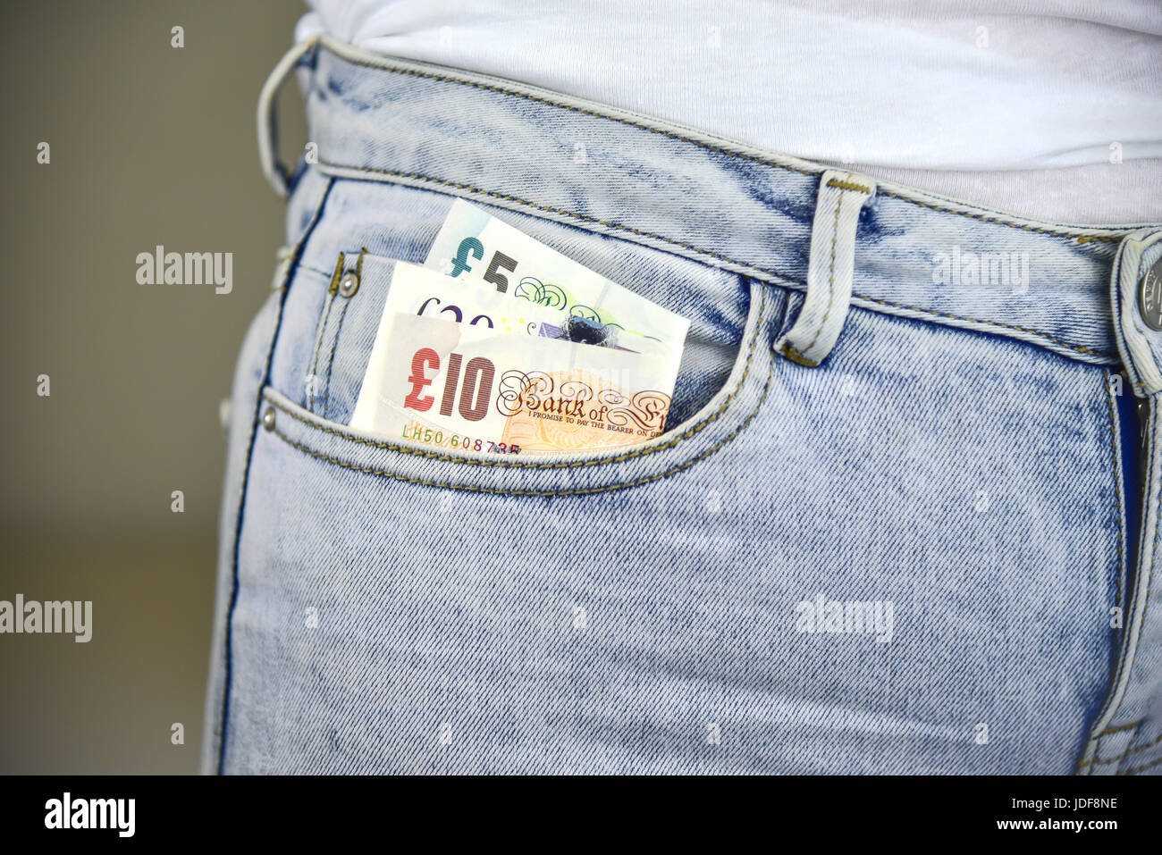 Money sticking out of a blue jean pocket Stock Photo - Alamy