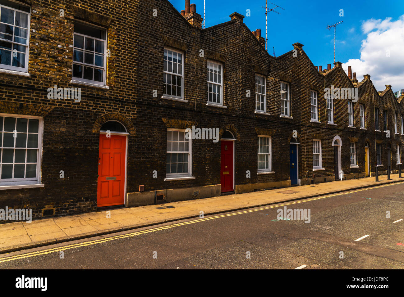 Typical old English buildings, low brick buildings across a narrow ...