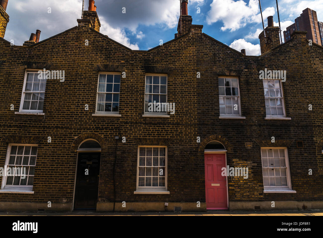 Typical old English buildings, low brick buildings across a narrow ...