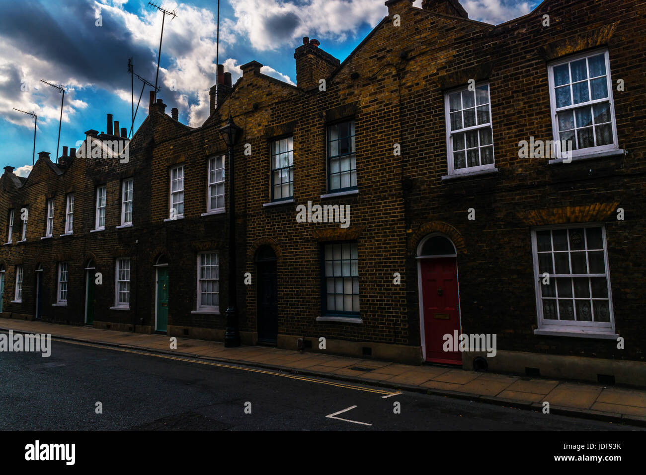 Typical old English buildings, low brick buildings across a narrow ...