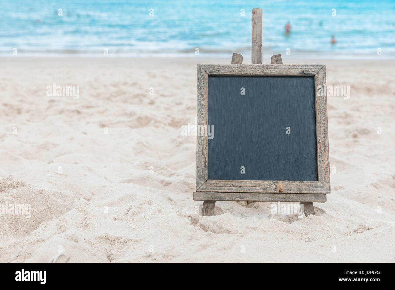 Chalk board with sunscreen cream in the sand on the beach tropic exotic ...