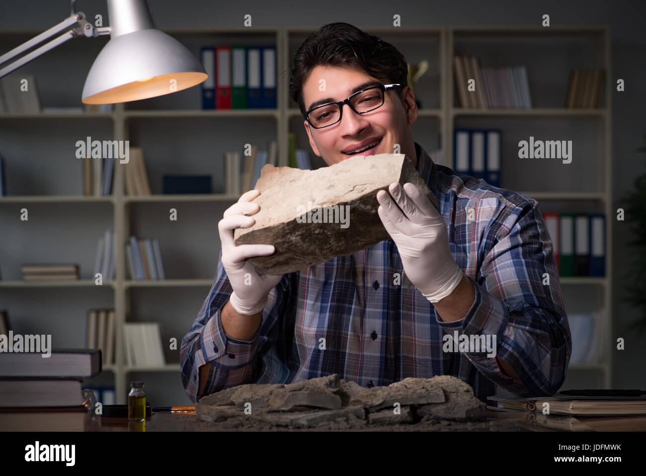 Archeologist working late night in office Stock Photo - Alamy