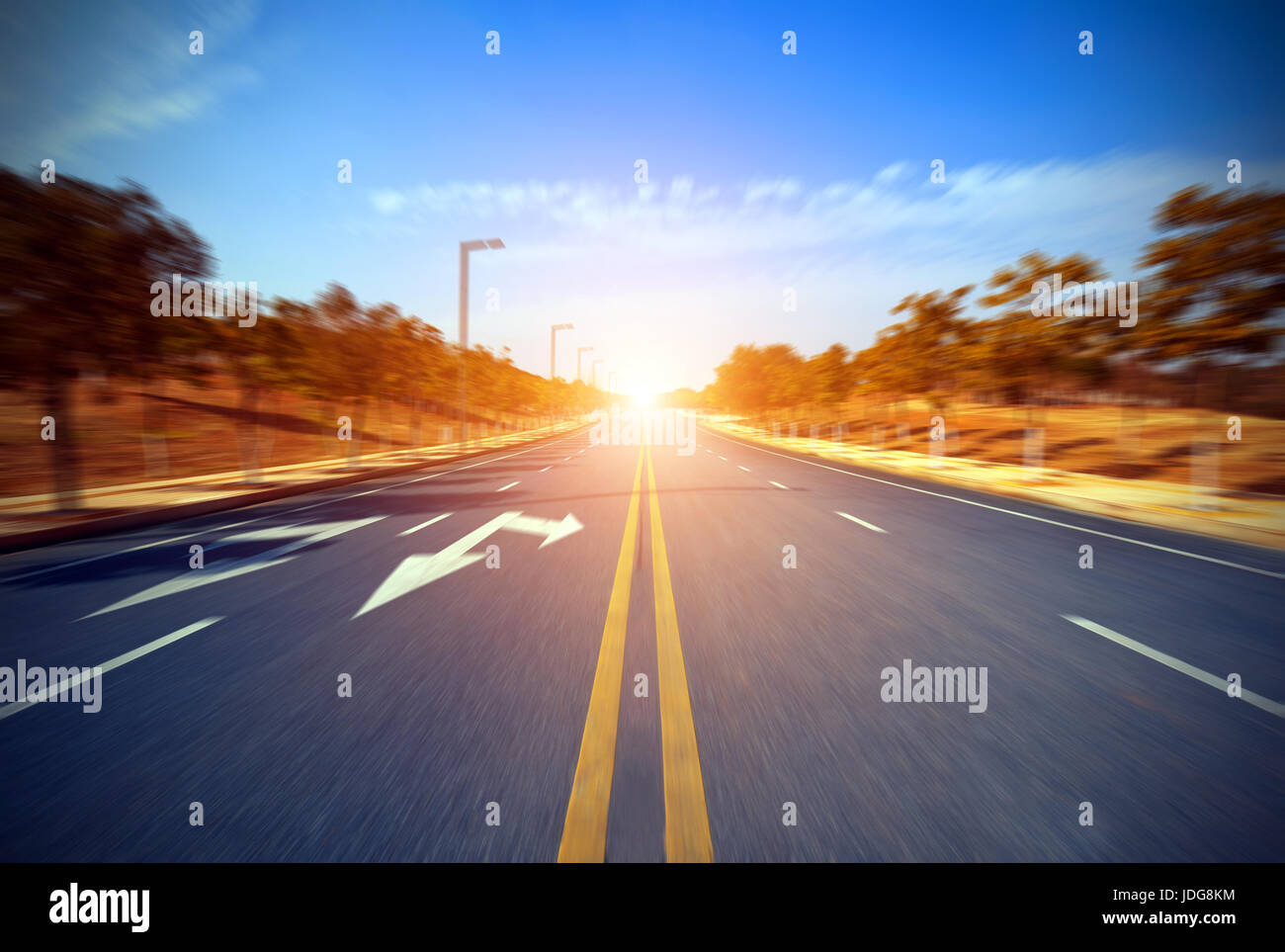 Asphalt blurry road and bright blue sky with clouds Stock Photo - Alamy