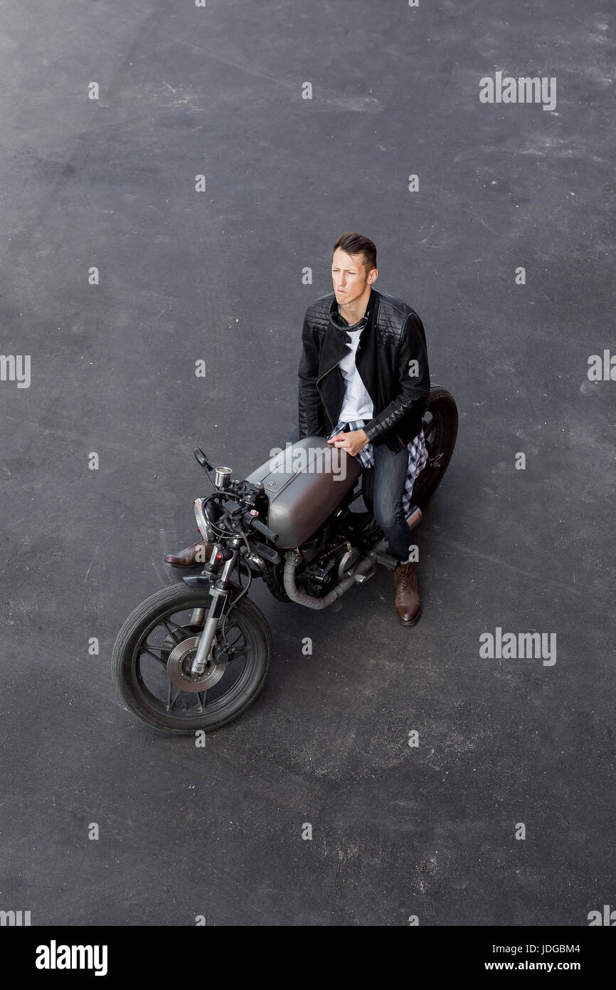 Top view of a handsome rider guy in black biker jacket, checkered shirt ...
