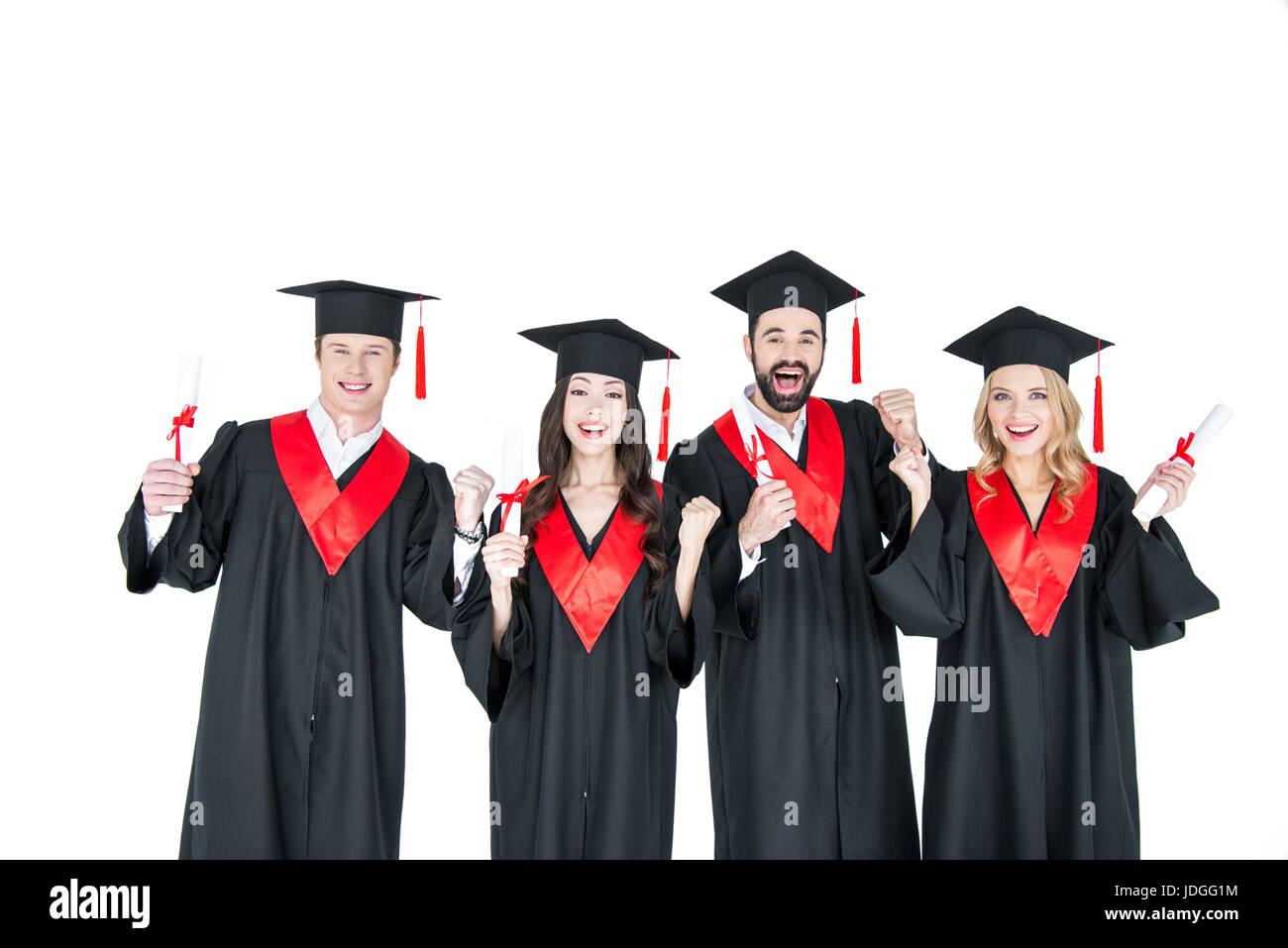 Happy young students in academic caps holding diplomas and smiling at ...