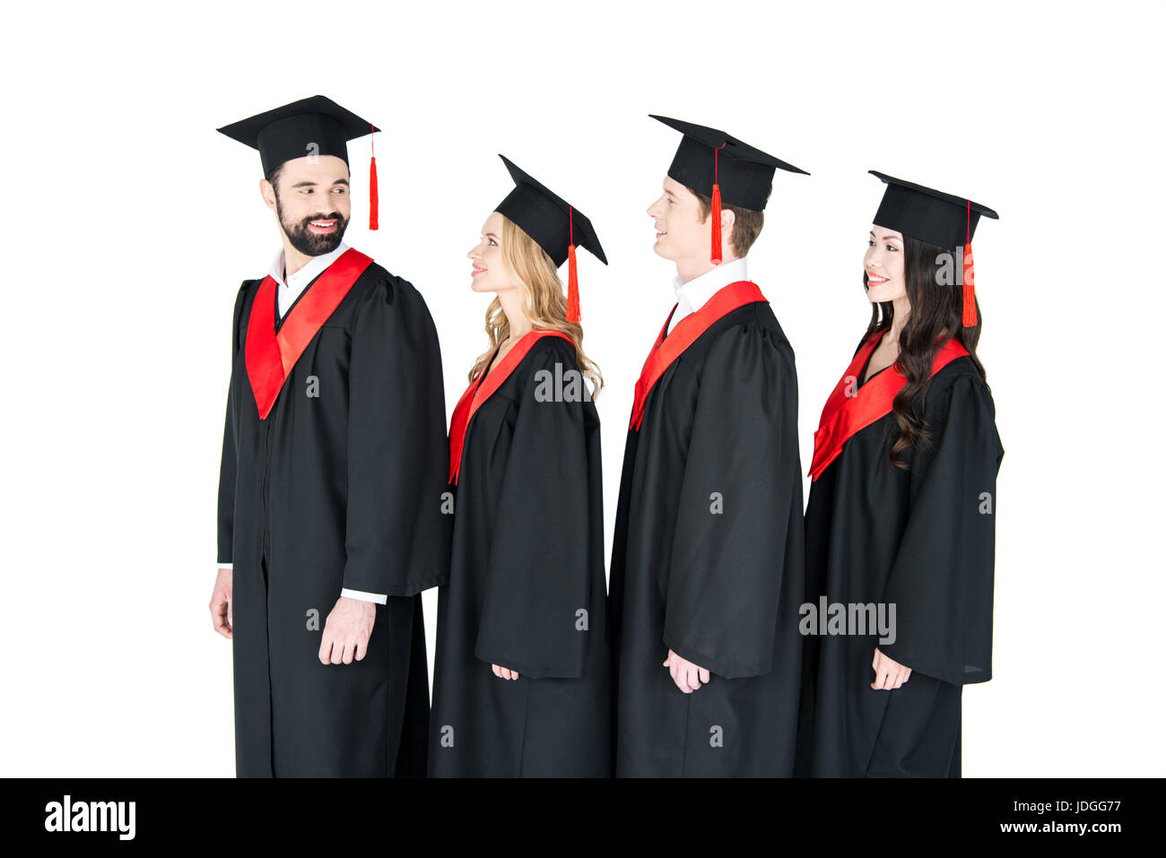 Smiling students in graduation caps standing in a row isolated on white ...