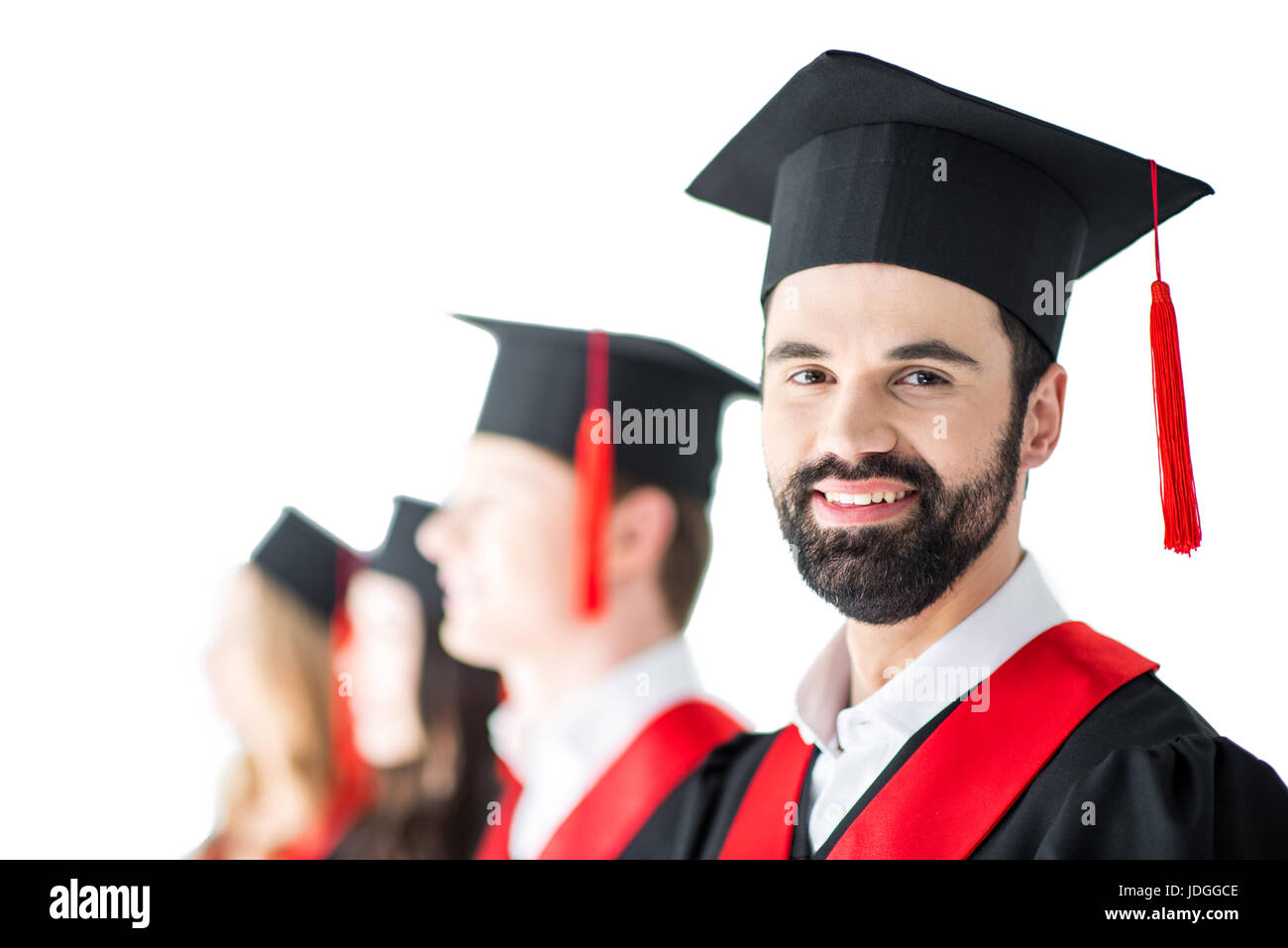 bearded student in graduation cap with diploma, with friends behind ...