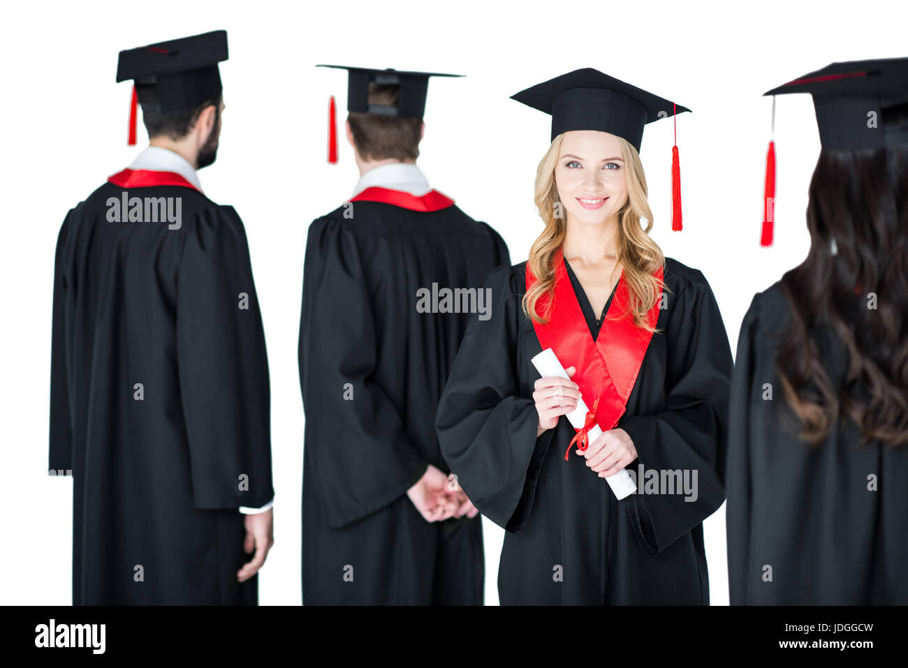 attractive student in graduation cap with diploma, with friends behind ...