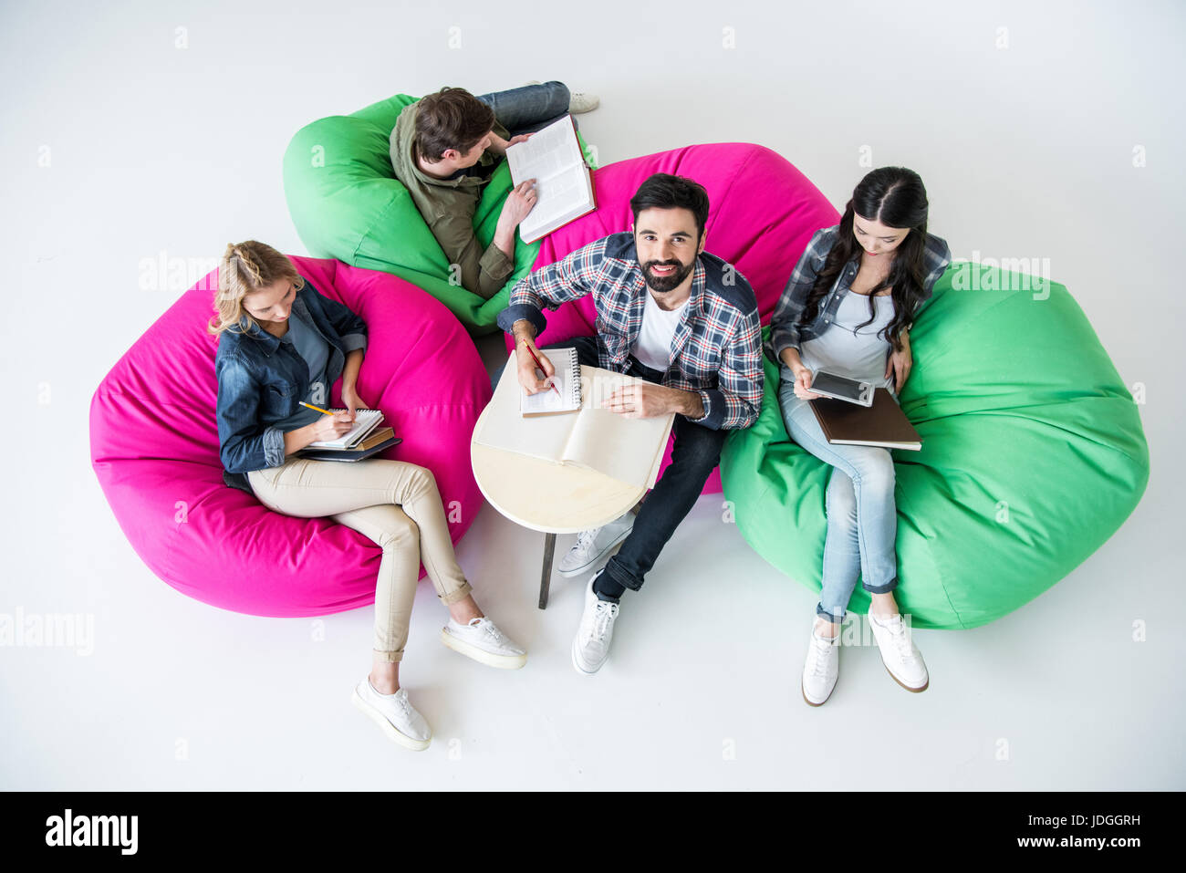 overhead view of students sitting on beanbag chairs and studying in ...