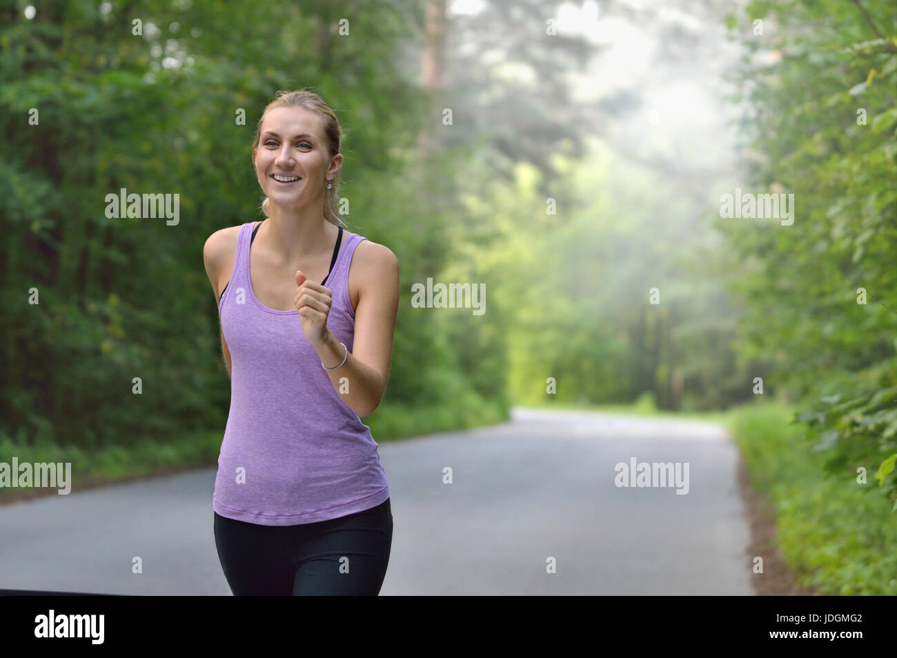 Female runner jogging during outdoor workout in a park. Fitness girl ...
