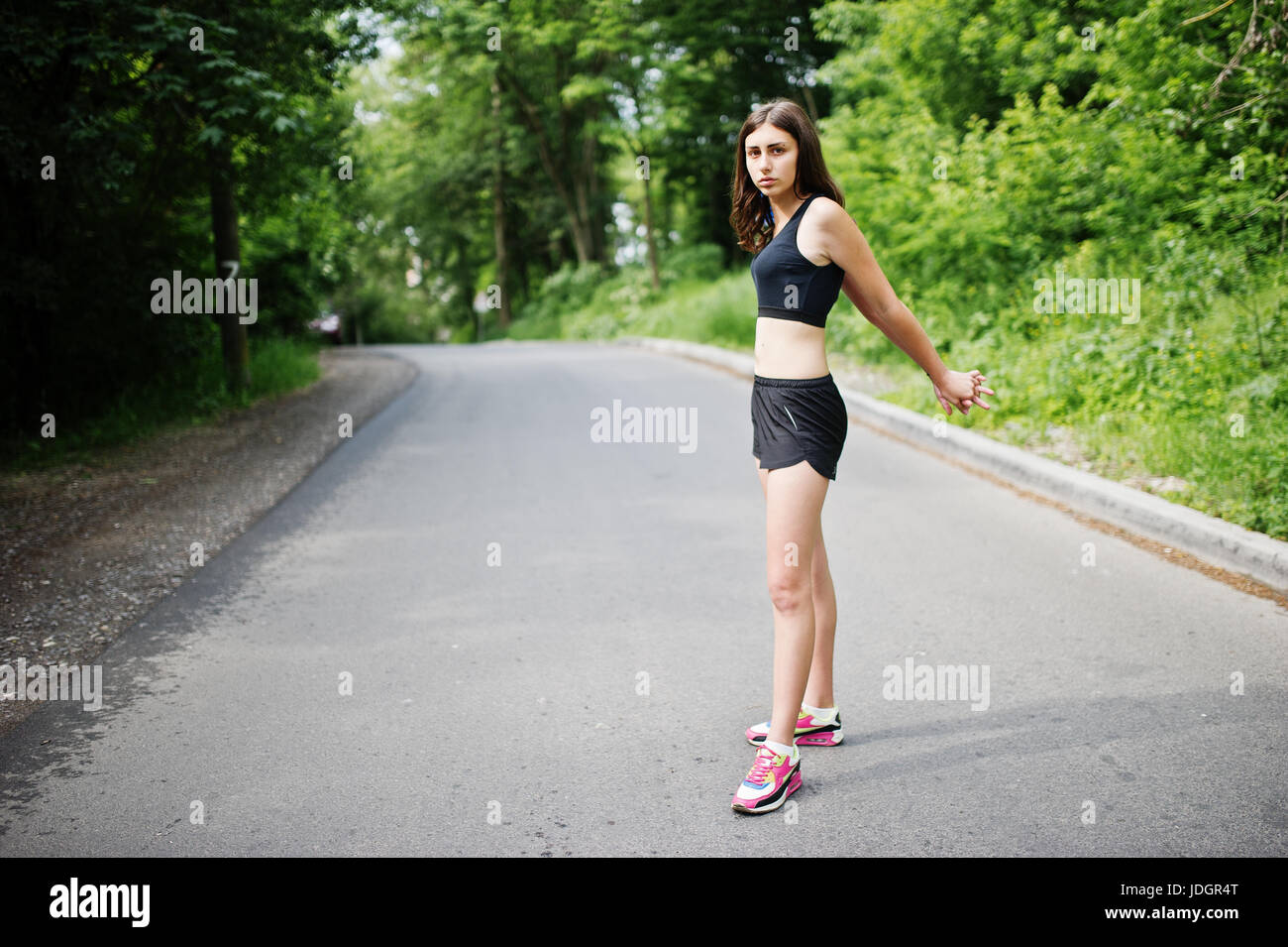 Sport girl at sportswear exercising in a green park and training at ...